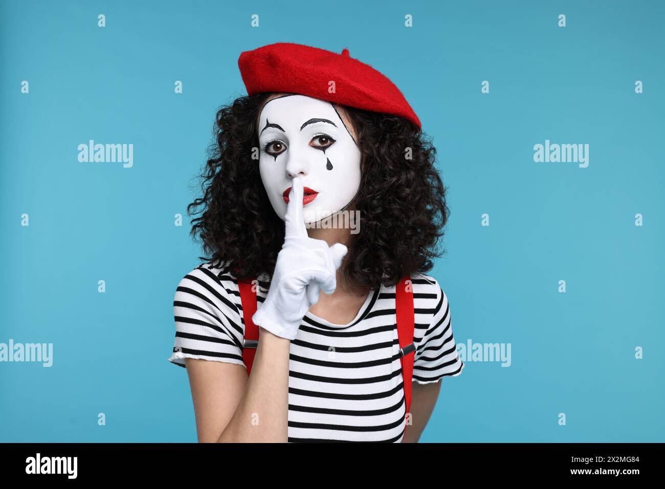 Funny mine with beret showing shush gesture on light blue background ...