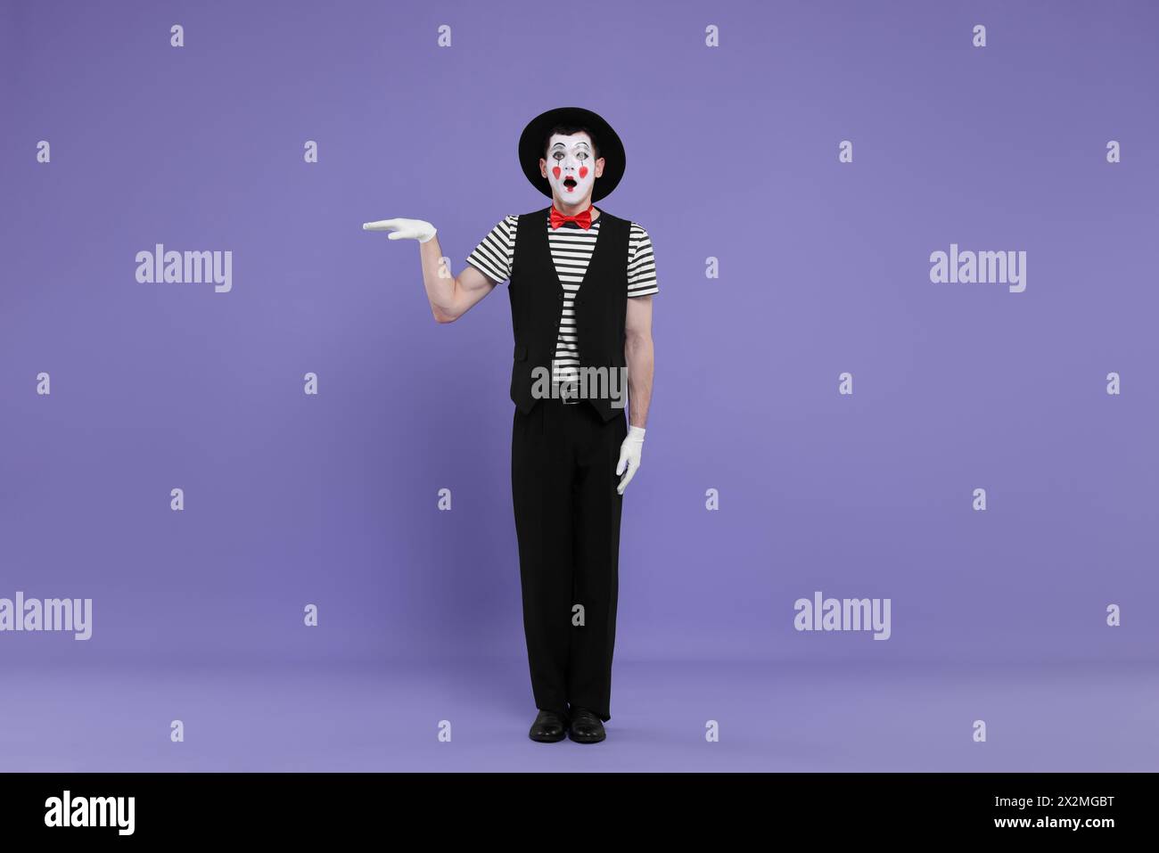 Mime artist making shocked face on purple background Stock Photo - Alamy
