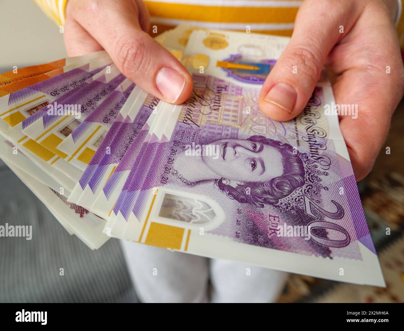 Close up of hands paying out cash money in UK 20 pounds banknotes Stock ...
