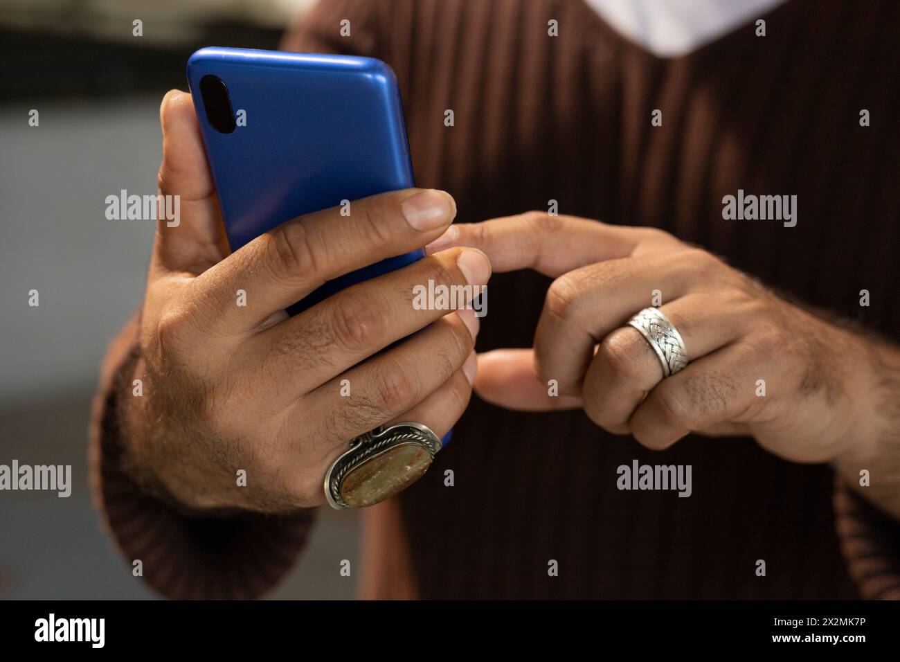 Close-up image of male hands with rings on their fingers, typing ...