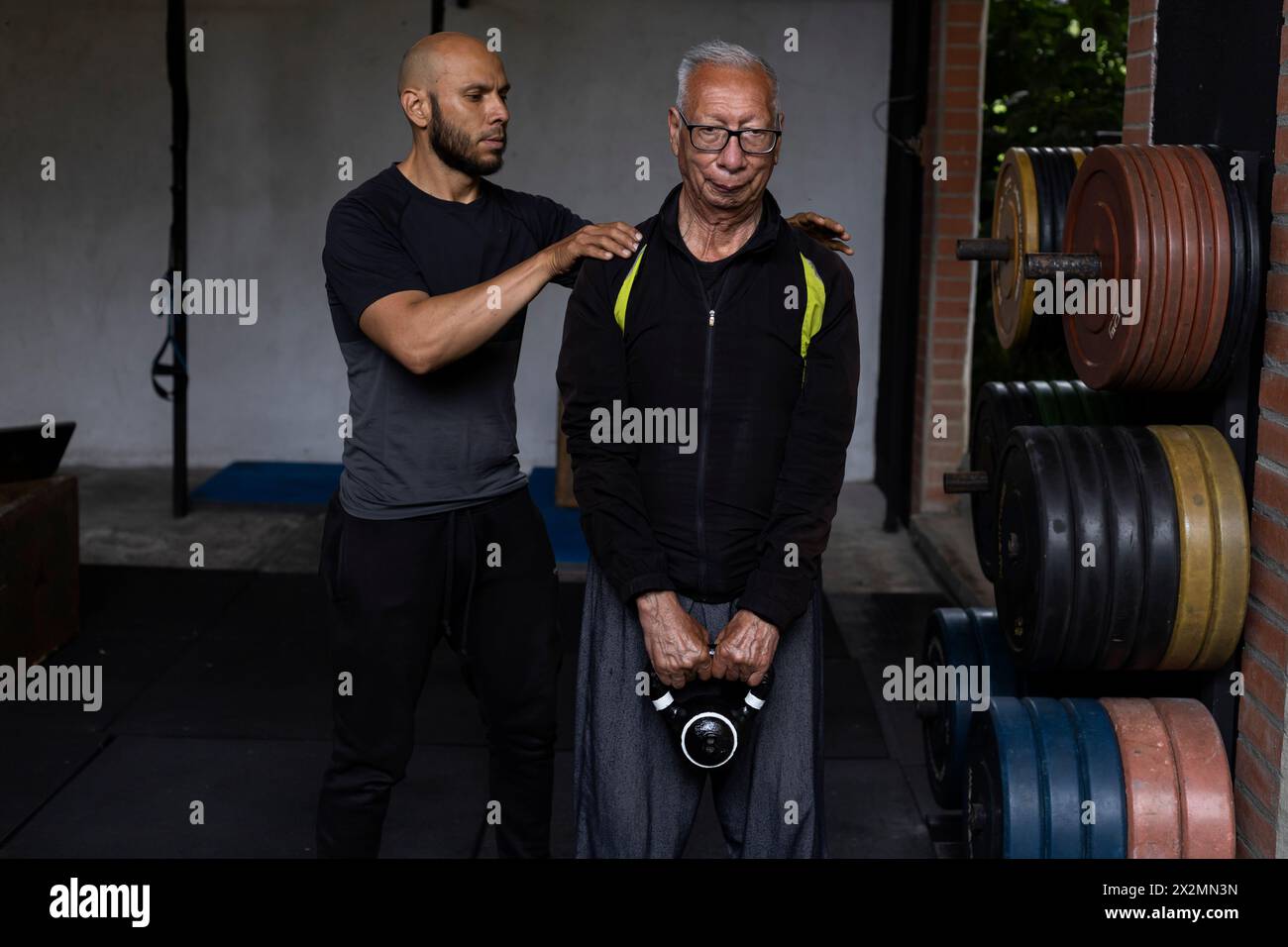 Latin American senior male with his personal trainer do rehabilitation ...