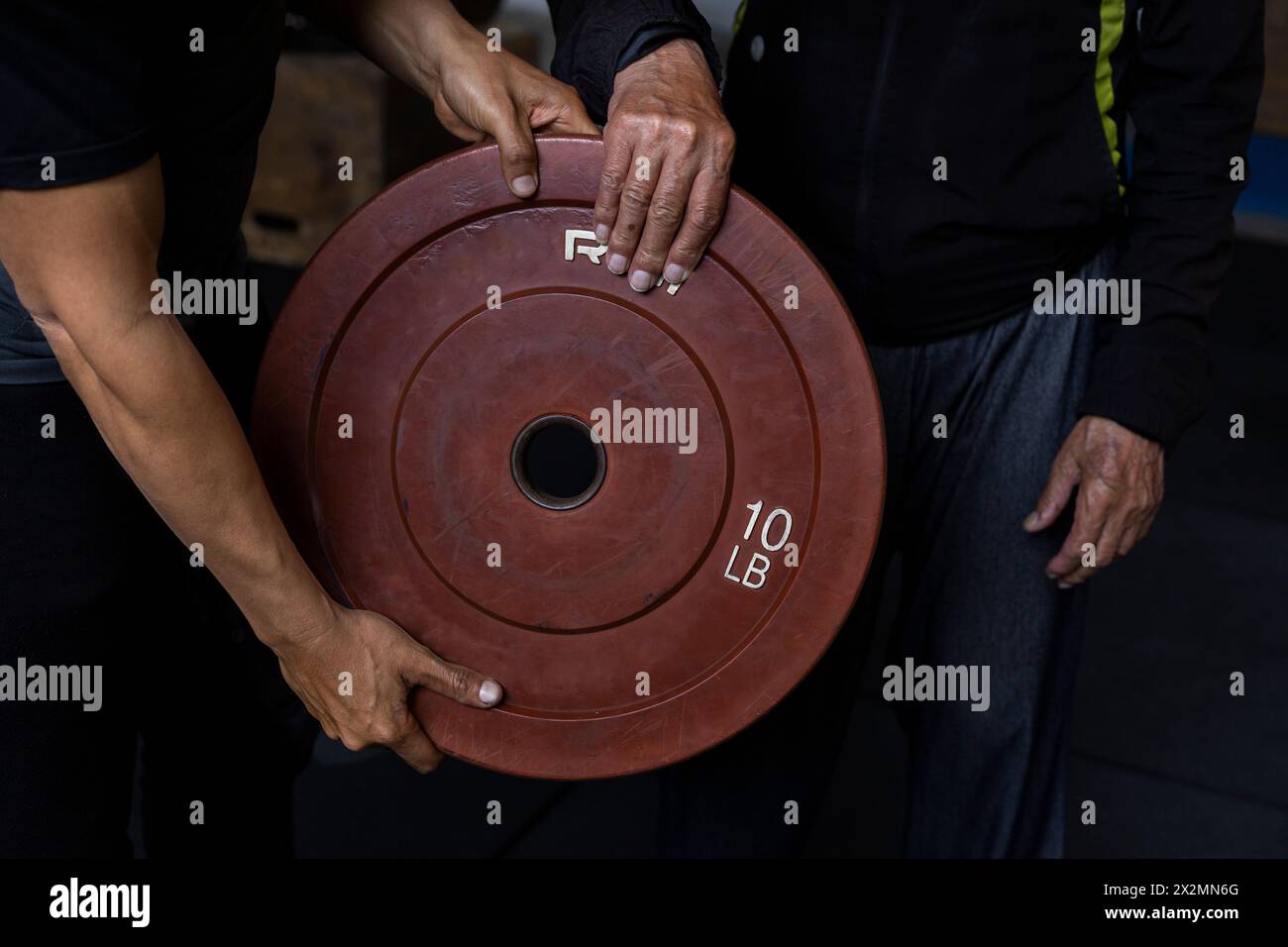 Unrecognizable Latin American elderly man and his trainer hold in their ...