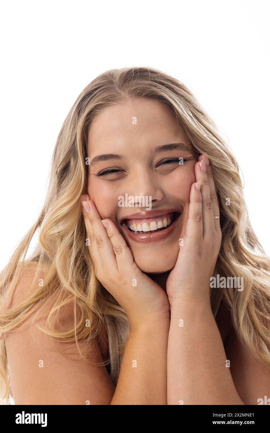 A young Caucasian plus size model laughs, touching her face on white ...