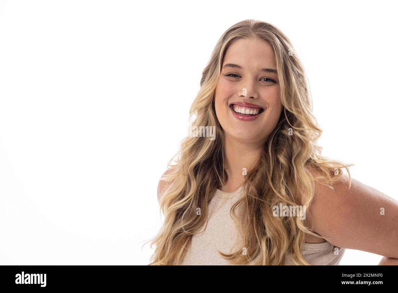 Laughing young Caucasian plus size model in sleeveless top on white ...