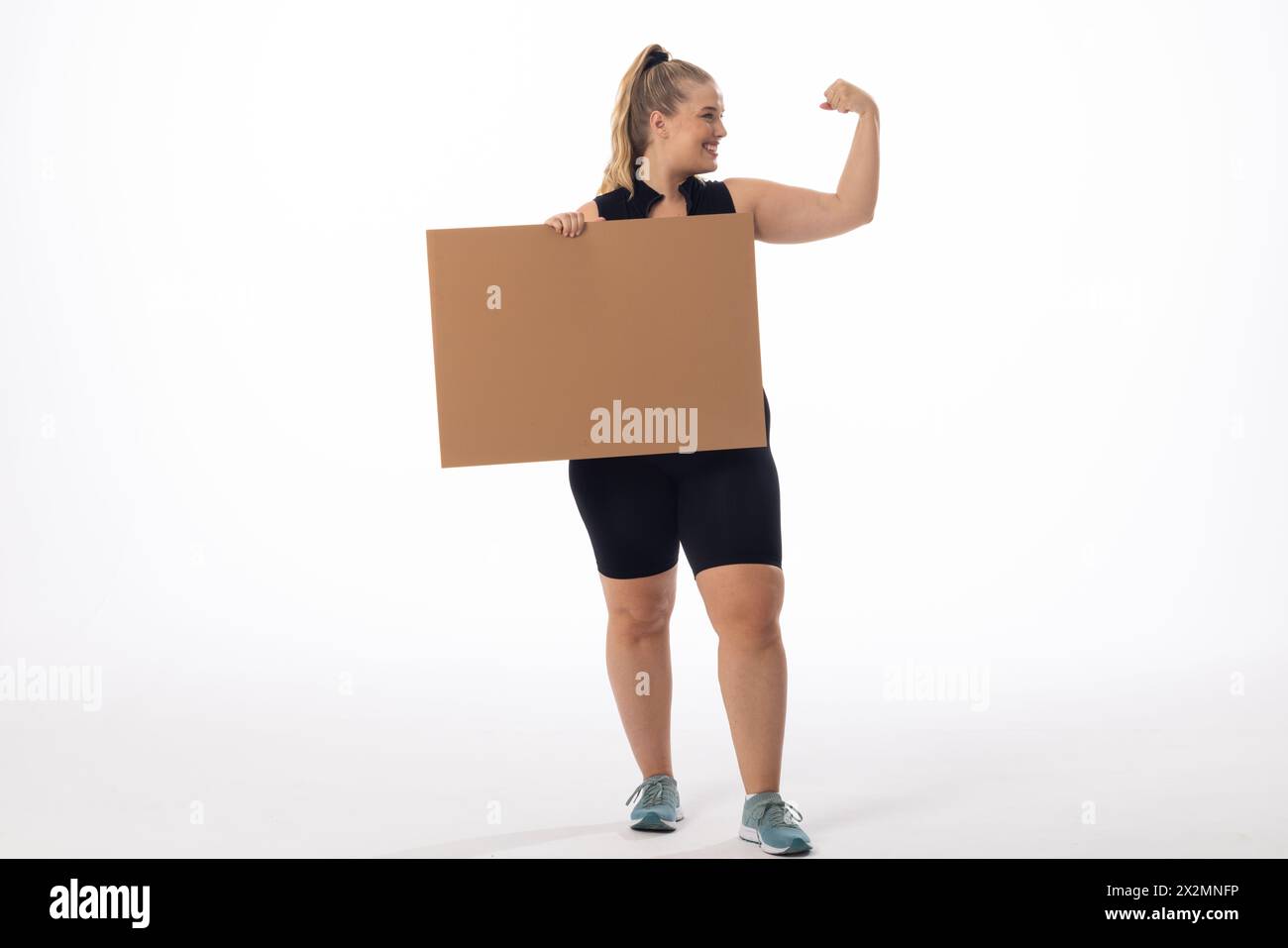 Plus size Caucasian woman shows strong arm, holds sign on white ...