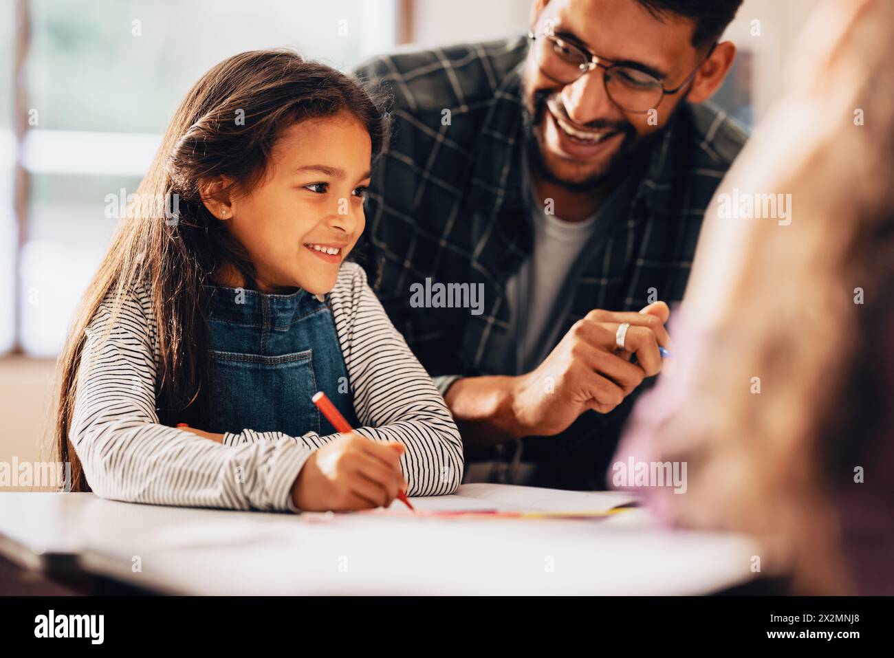Mentoring children at elementary level. Girl smiles happily as she ...