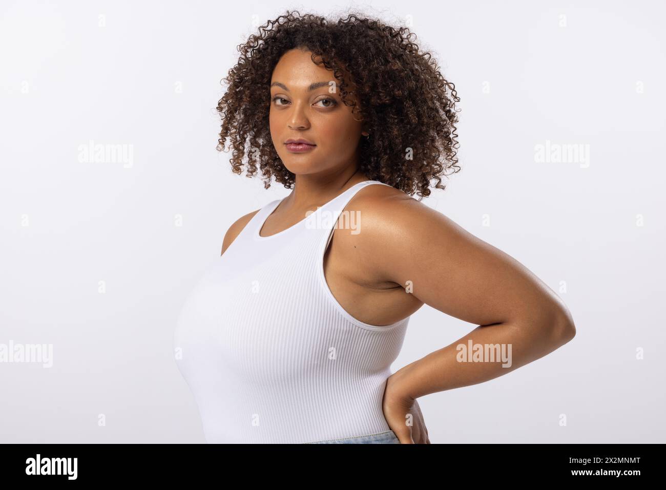 A biracial young female plus size model poses on white background, copy ...
