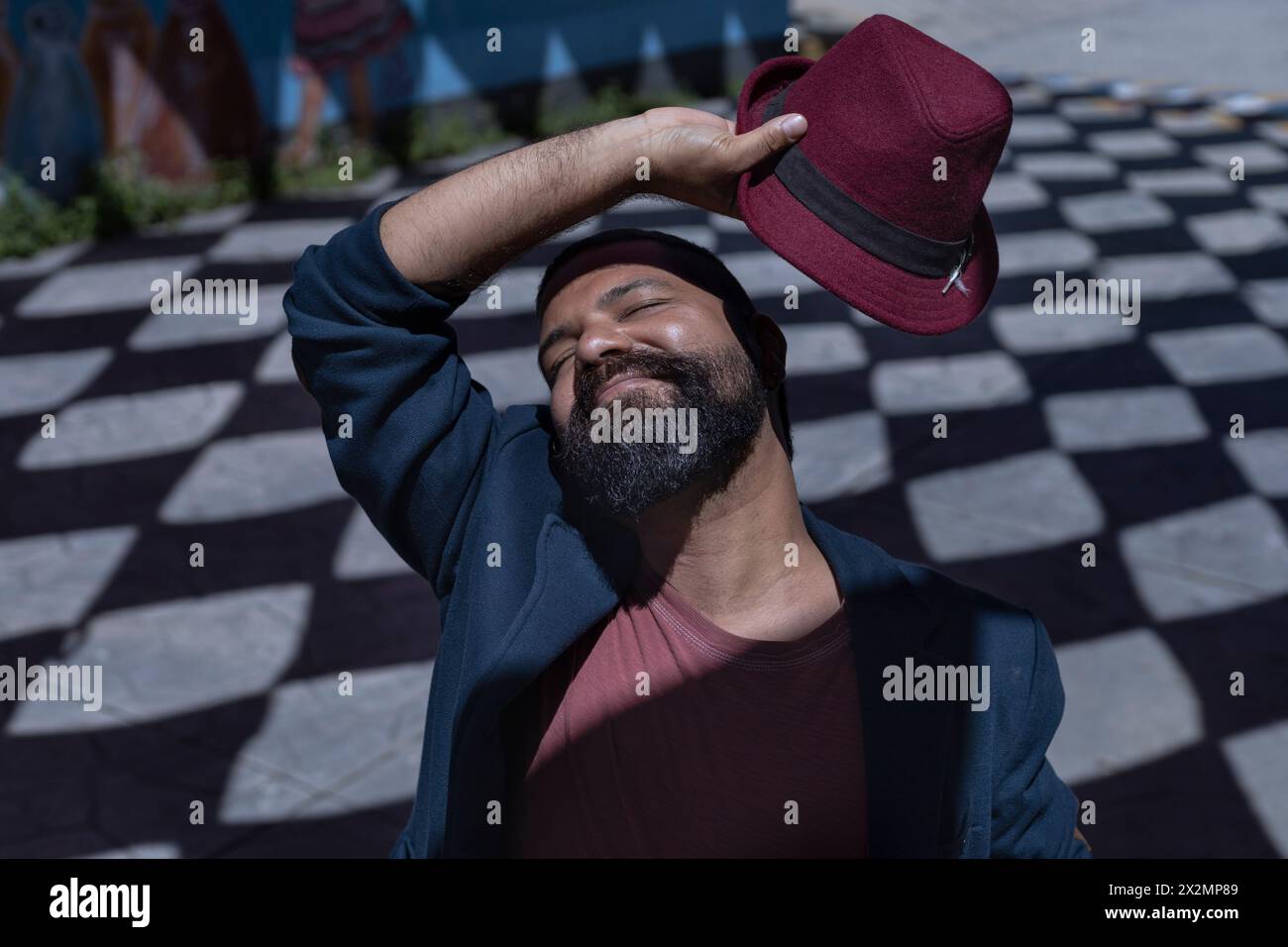 Portrait of Latin American bohemian man with closed eyes, beard, hat ...