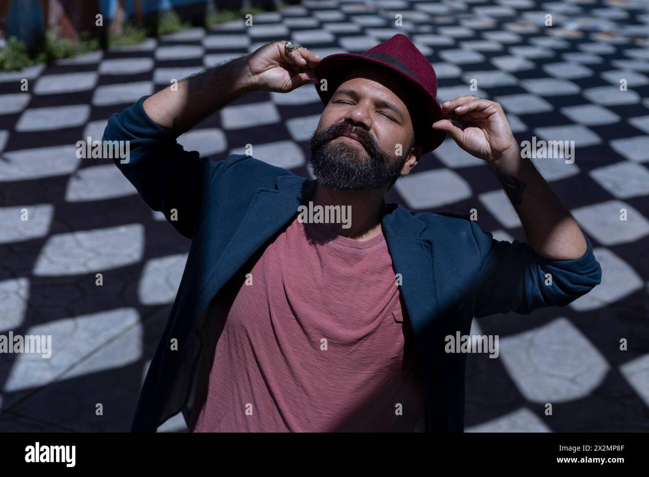 Portrait of Latin American bohemian man with closed eyes, beard, hat ...