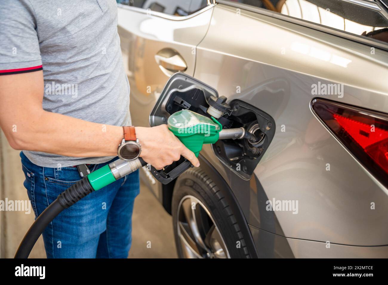 The driver fills up expensive gasoline in self-service filling station ...