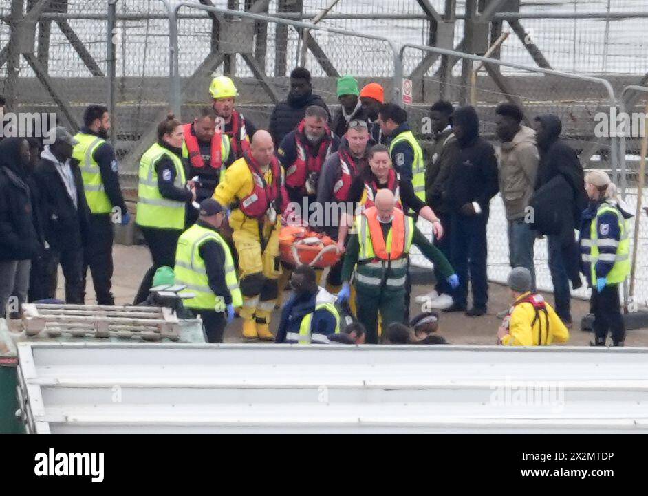 A person is carries on a stretcher as a group of people thought to be ...