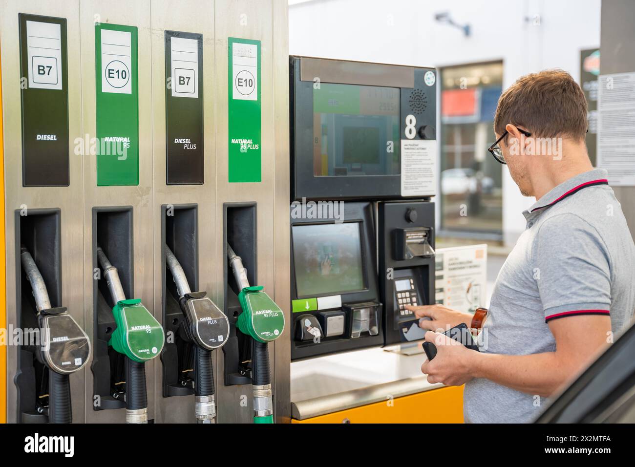 The man pays for fuel with a credit card on terminal of self-service ...
