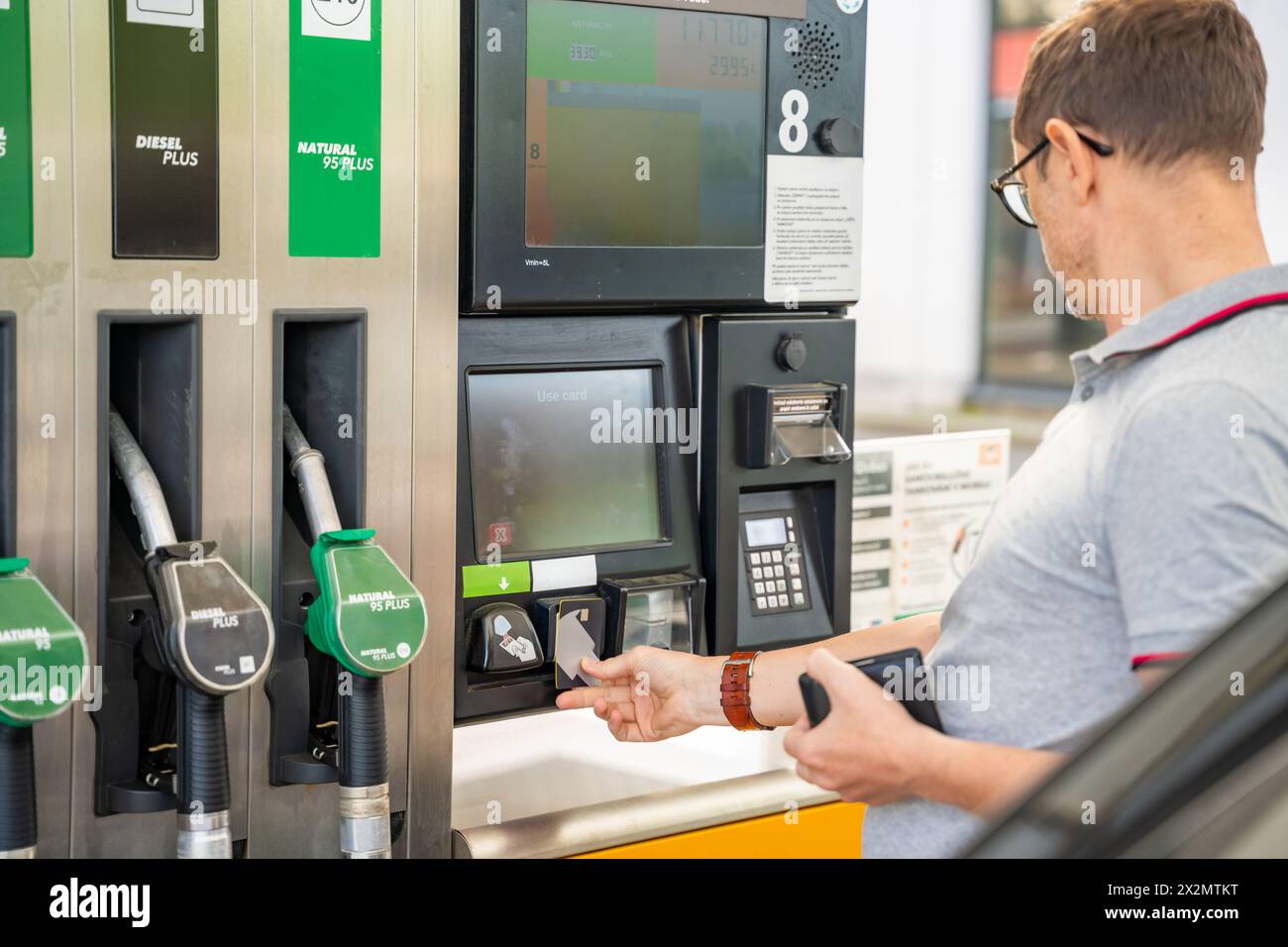 The man pays for fuel with a credit card on terminal of self-service ...