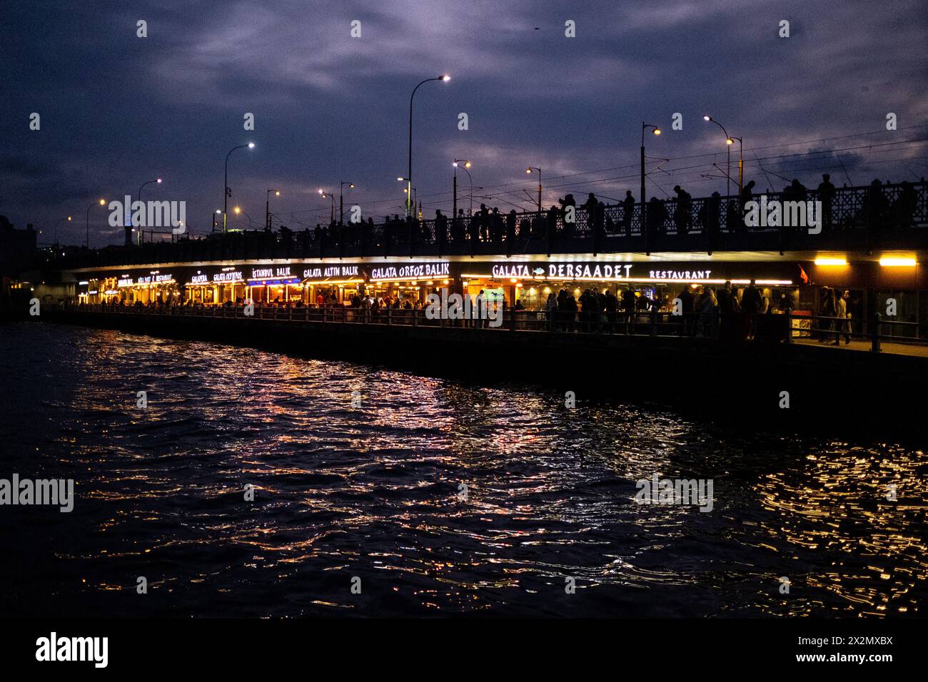 Fishermen on the Galata Bridge on the Golden Horn estuary at dusk ...
