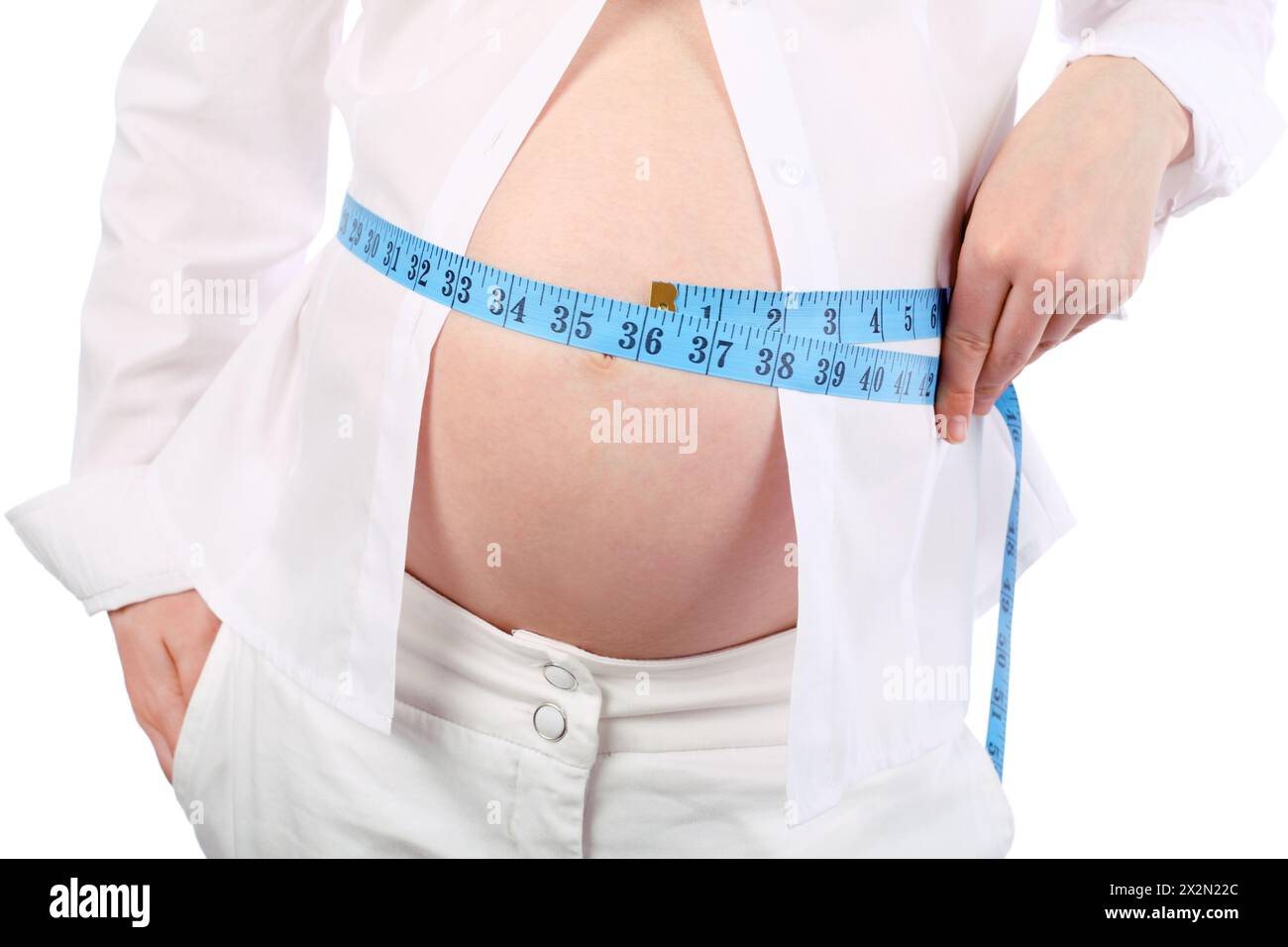 Belly of pregnant woman in white measuring belly by blue centimeter ...