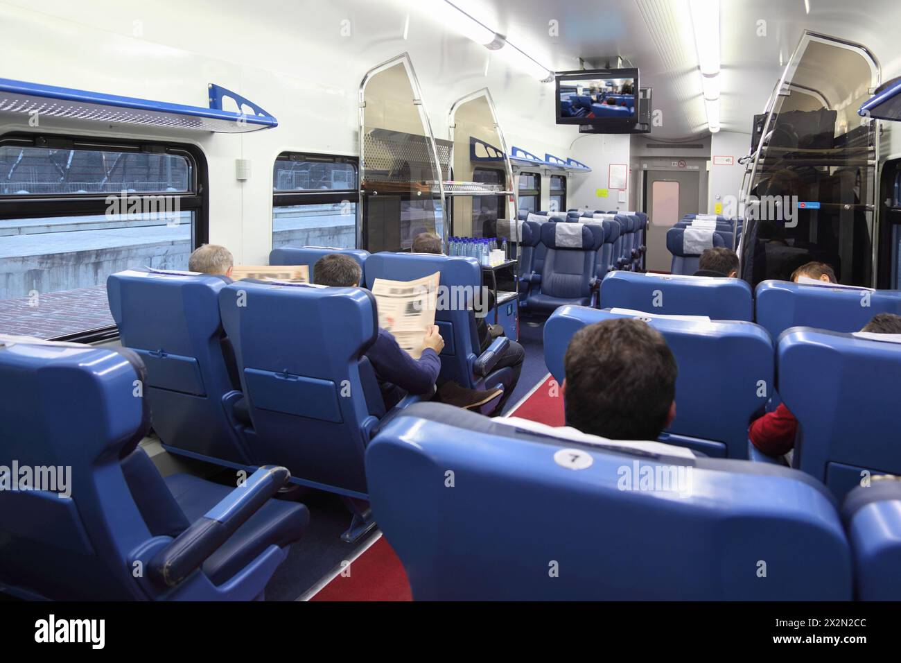 Back of passengers sitting in soft blue chairs in train carriage Stock ...