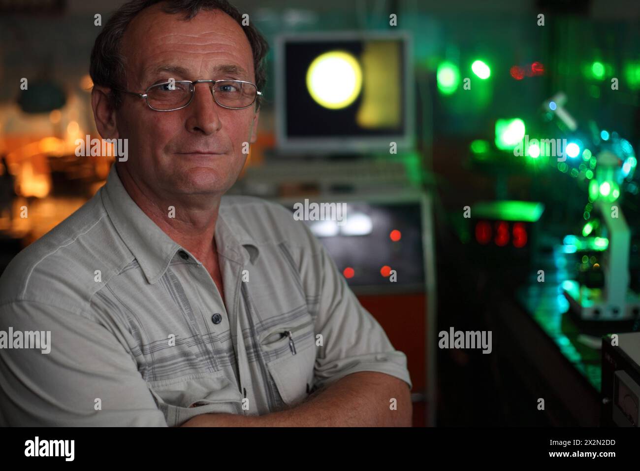 Scientist with glass pose in his lab of movement of microparticles by ...