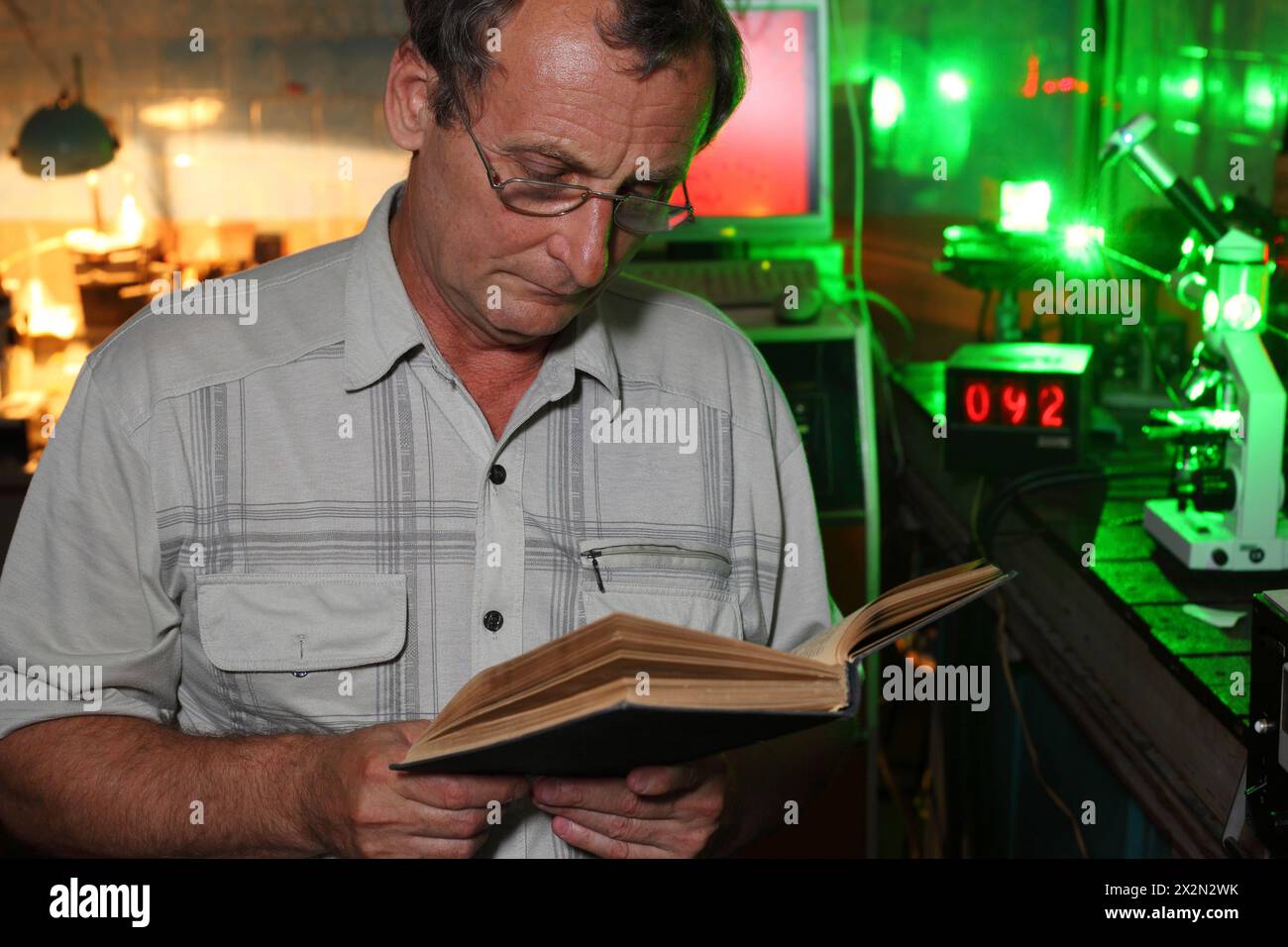 Scientist with glass read book in his lab of movement of microparticles ...