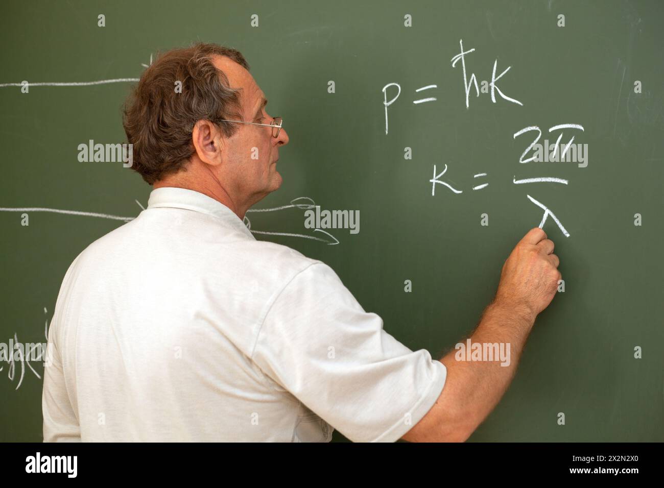 Scientist solves equation on blackboard, back Stock Photo - Alamy
