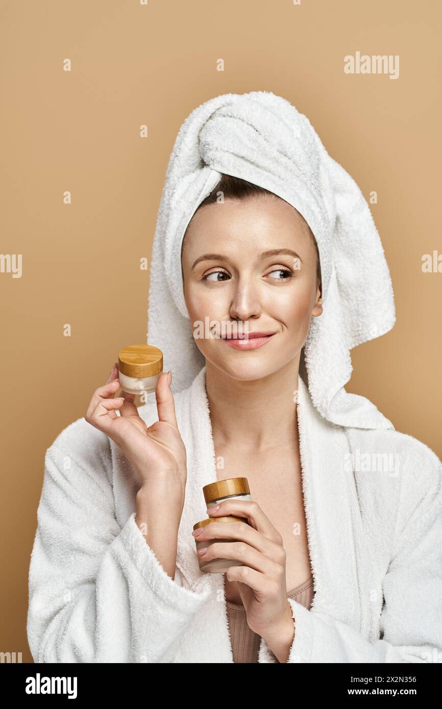 A captivating woman in a white robe gracefully holding a jar of cream ...