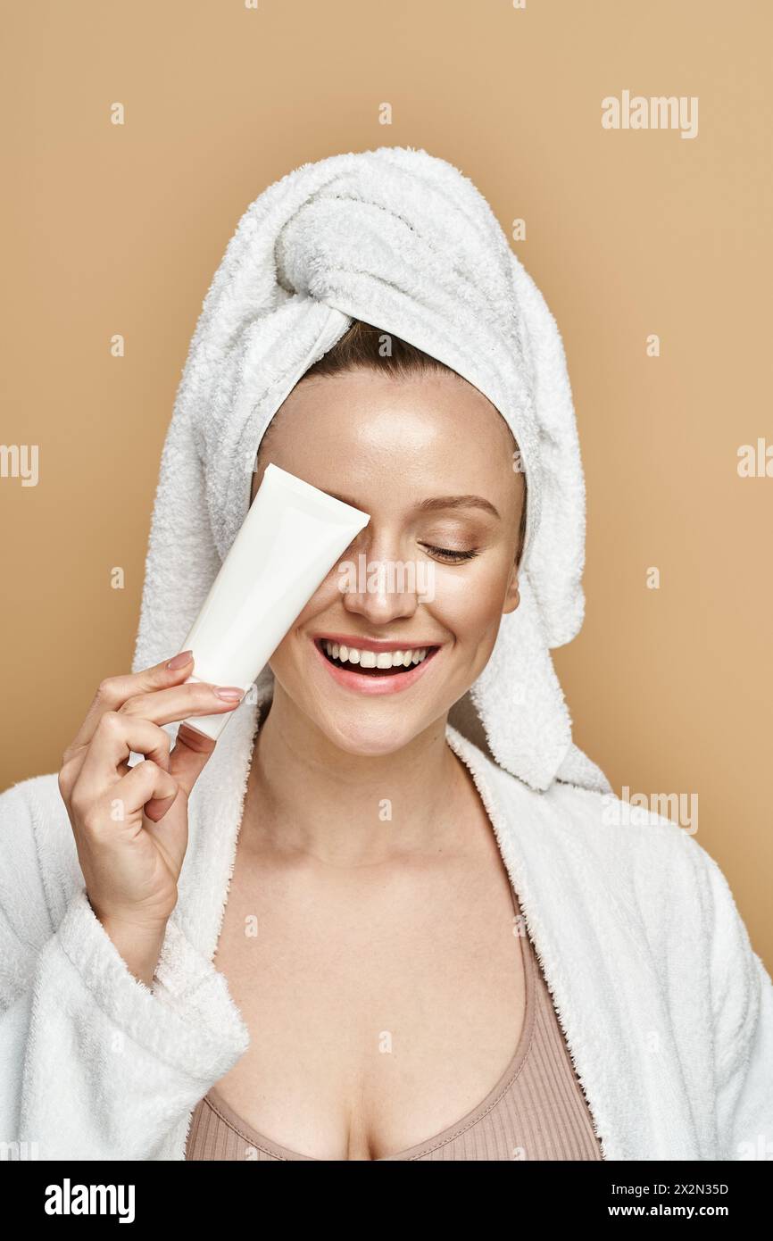 A natural beauty poses actively with a towel wrapped around her head ...