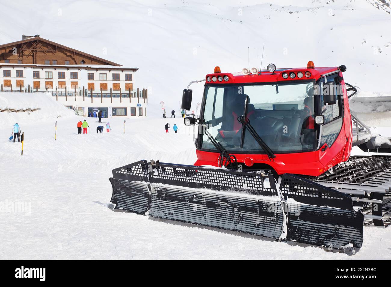 Red machine for skiing slope preparations in Austrian Alps, building ...