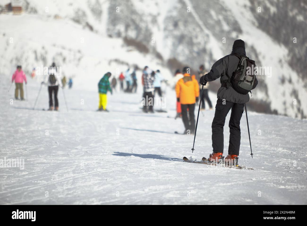 Group of skiers on snowy hillslope, focus on nearest skier Stock Photo ...