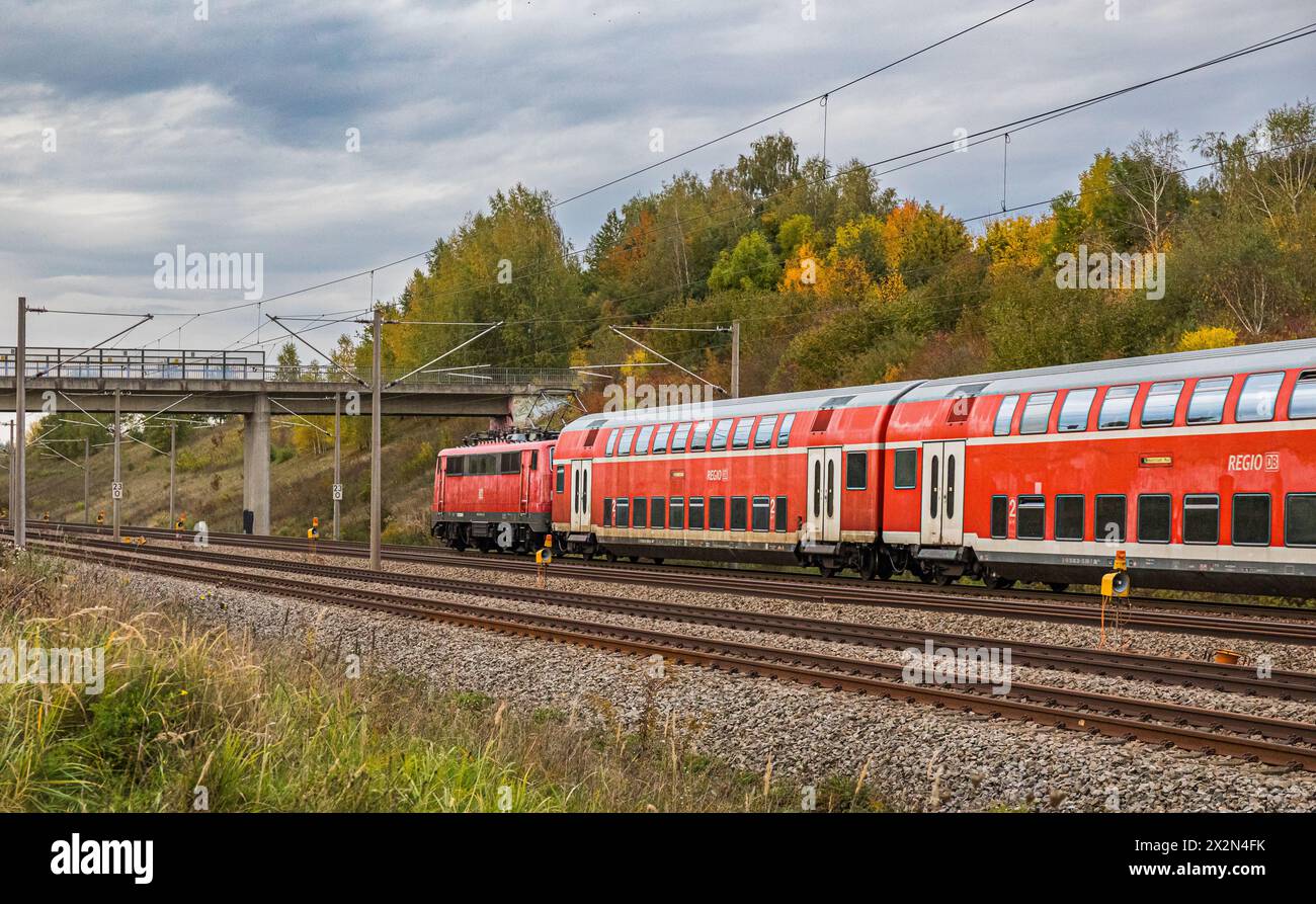 Ein Personenzug mit einer Lokomotive der Baureihe 111 der Deutschen Bahn ist mit ...