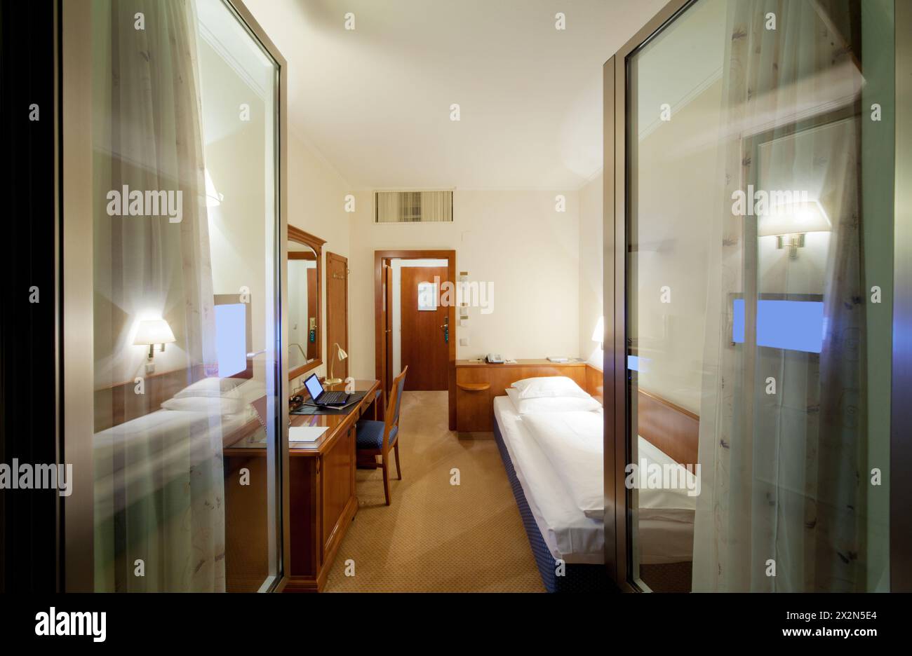 Hotel room with bed, tv, mirror, notebook, open windows Stock Photo - Alamy