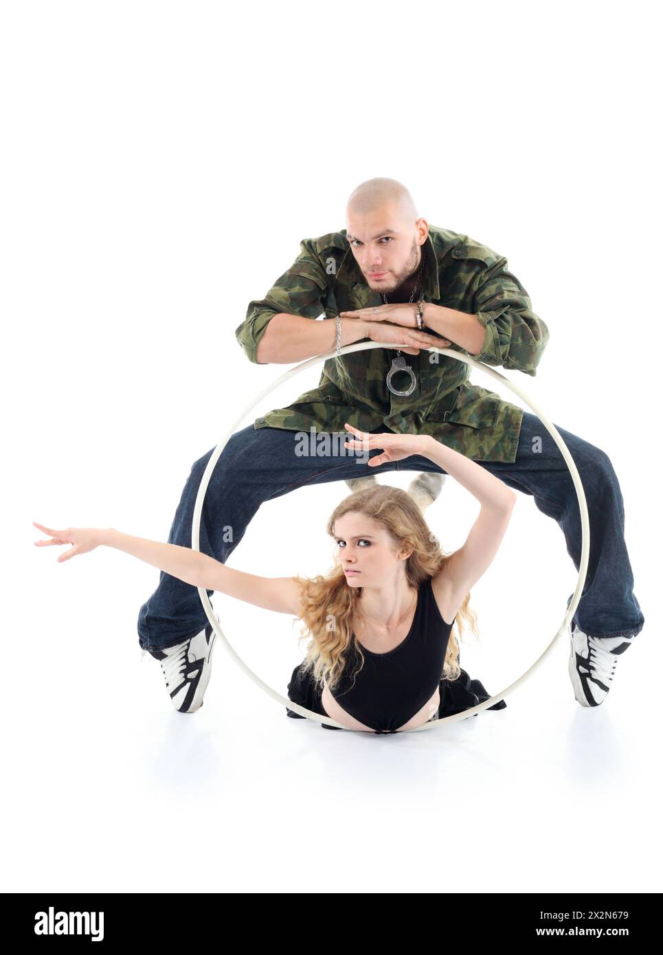 Rapper stands over girl and puts hands on hoop and gymnast girl lies on ...