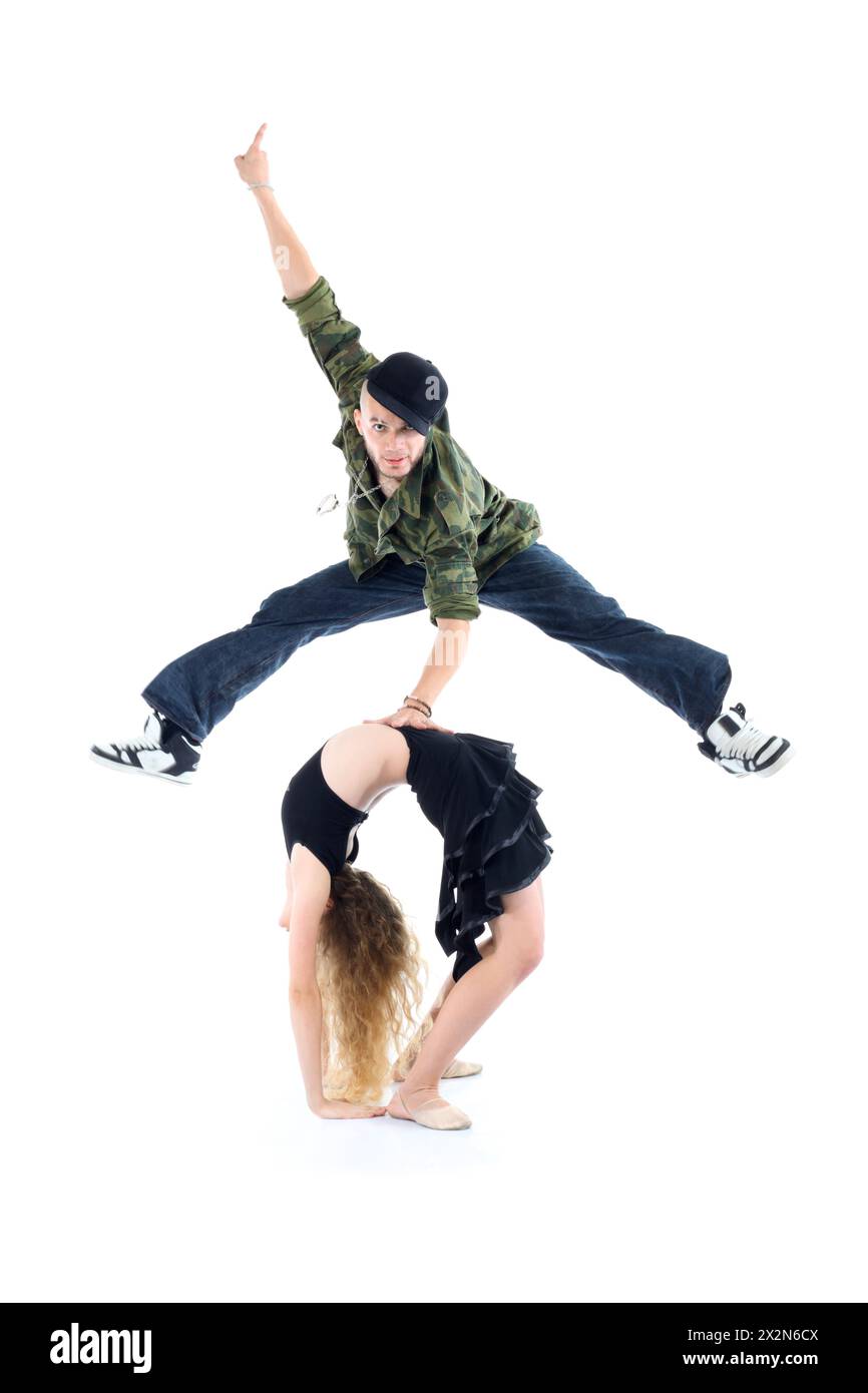 Gymnast does bridge and smiling rapper jump above her isolated on white ...