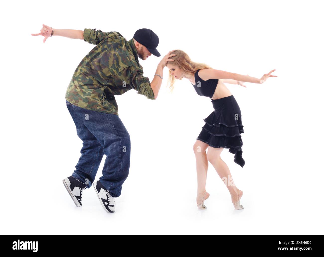 Gymnast in black dress and rapper stand on tiptoe, arms tossed back ...