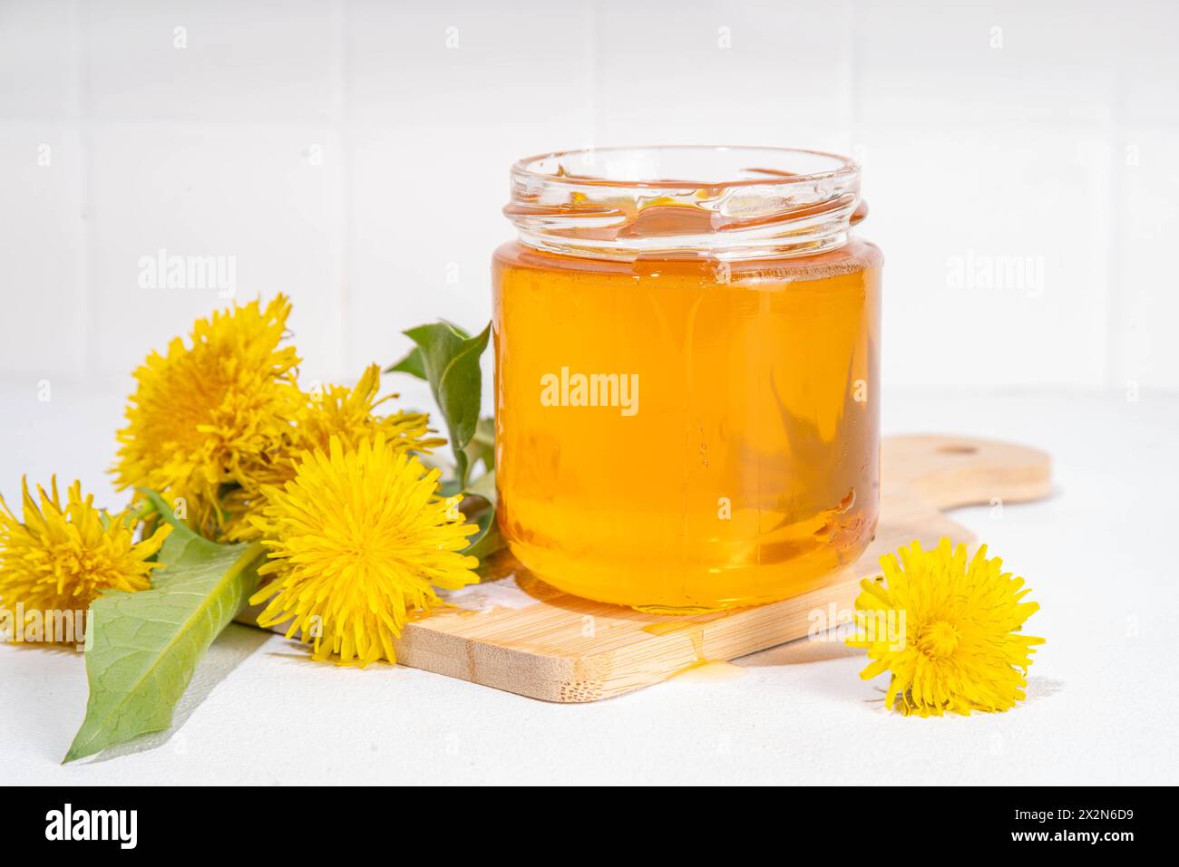 Dandelion jam, jelly confiture in a jar with fresh dandelion flowers on ...