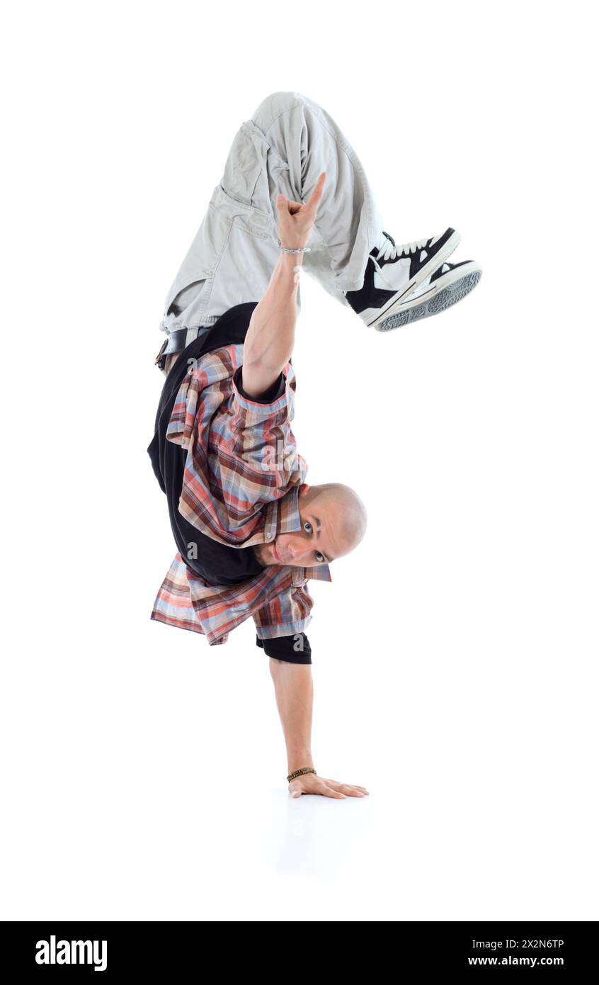 Breakdancer stands on one hand and points up isolated on white ...