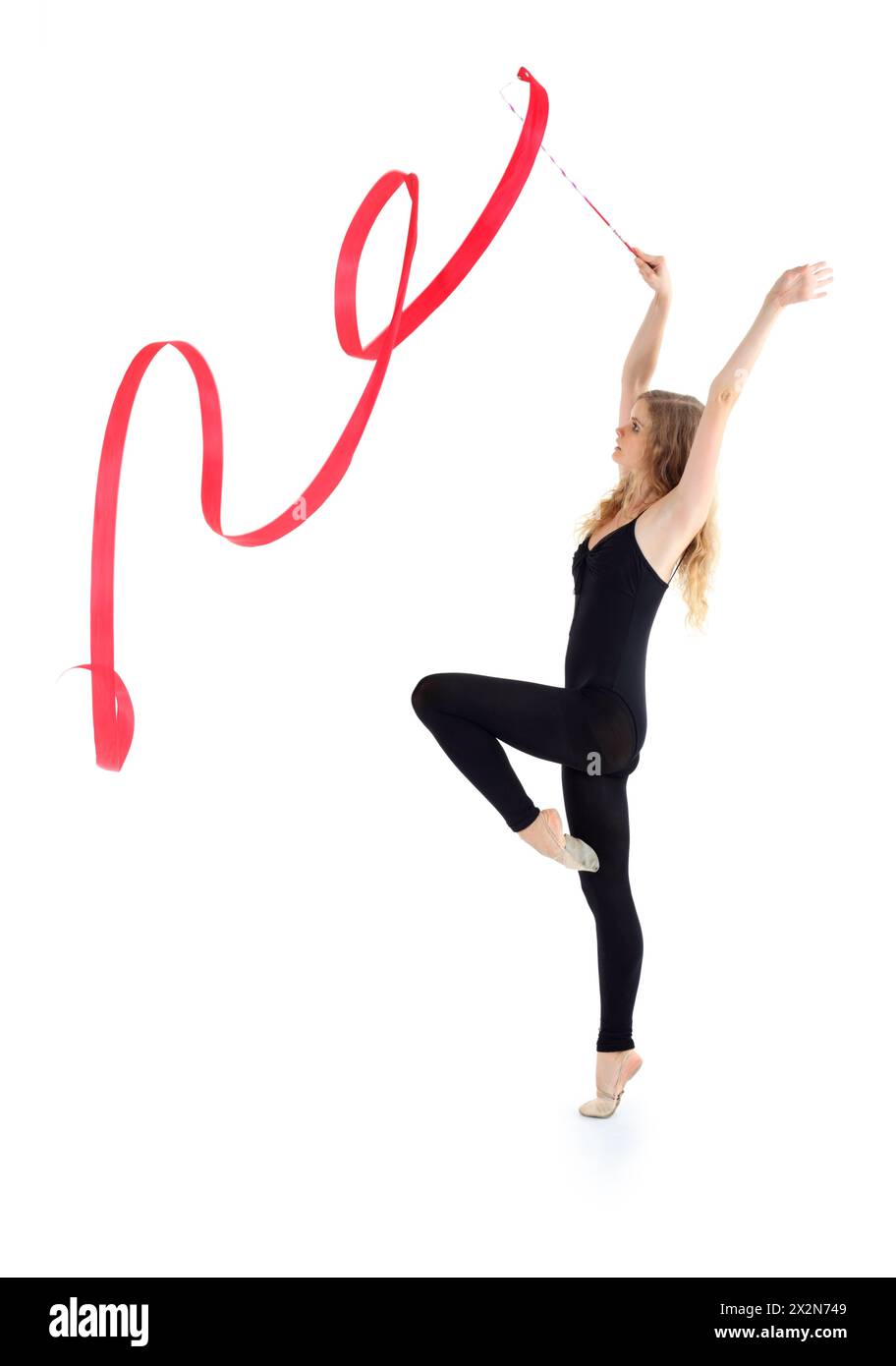 Beautiful ballerina in black suit with red ribbon stands on tiptoe on ...