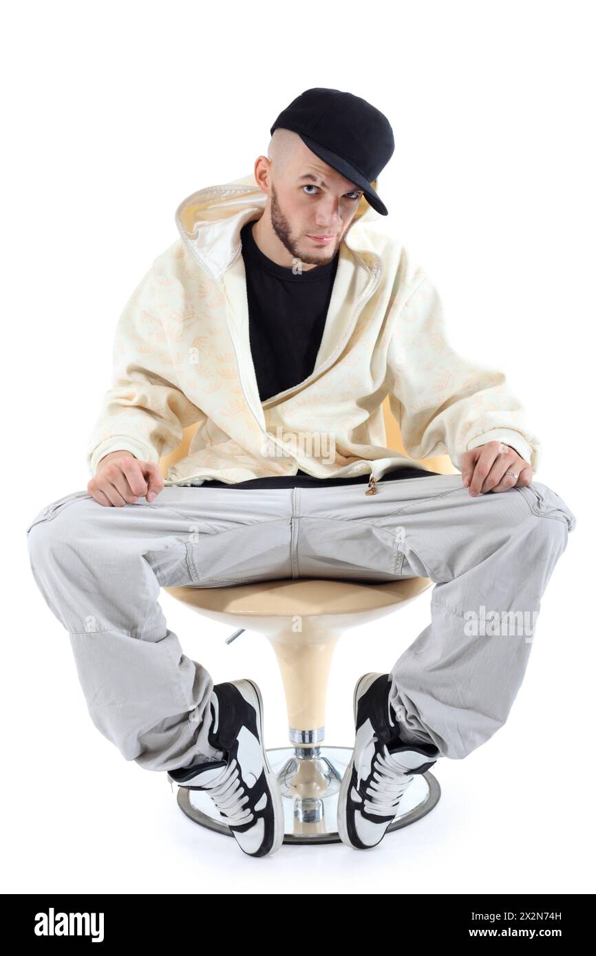 Rapper in yellow jacket sits on yellow chair and looks at camera ...