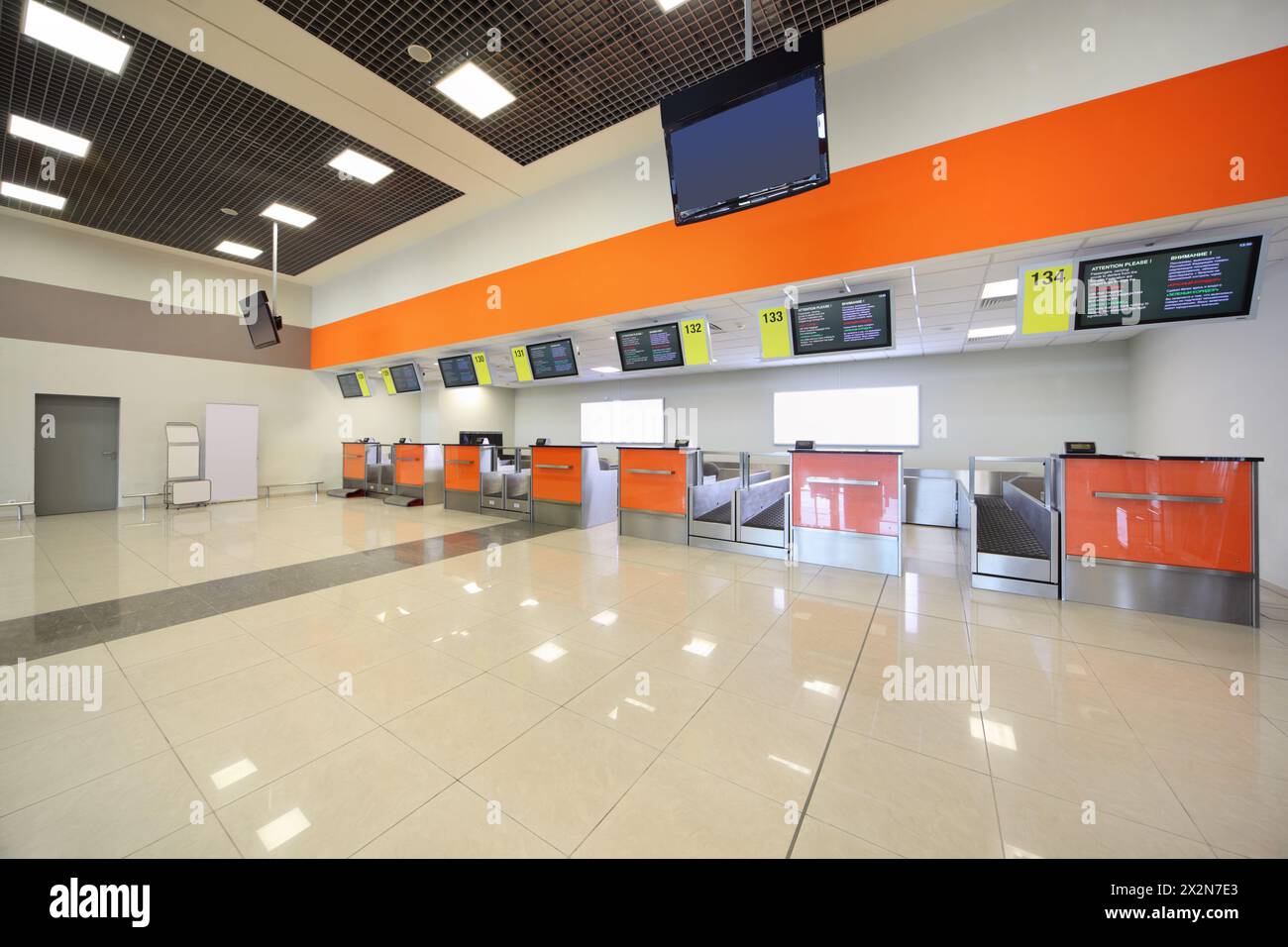 Empty terminal at airport, orange interior decoration, displays with ...