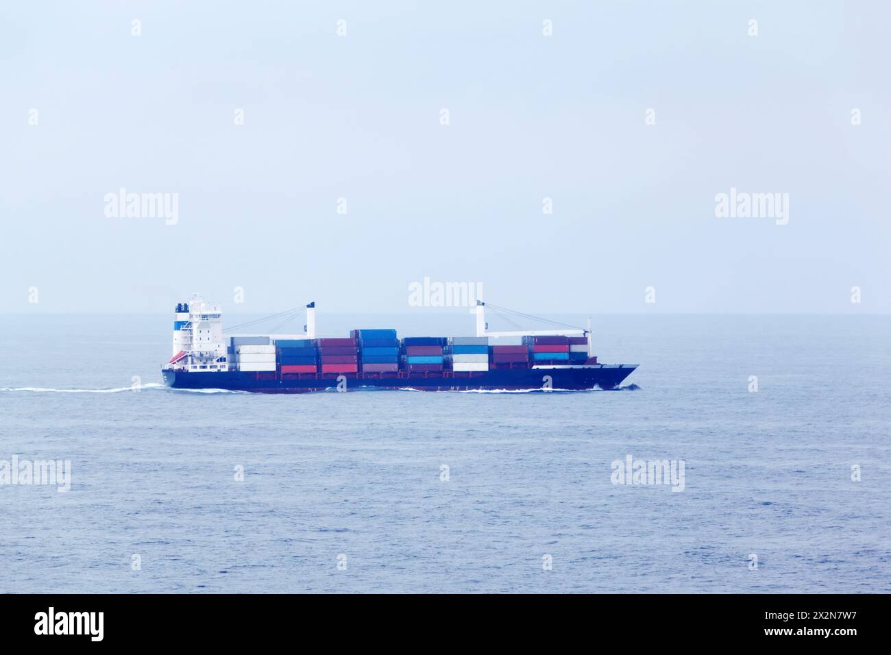 Large cargo ship floats in open ocean, many containers stand at deck ...