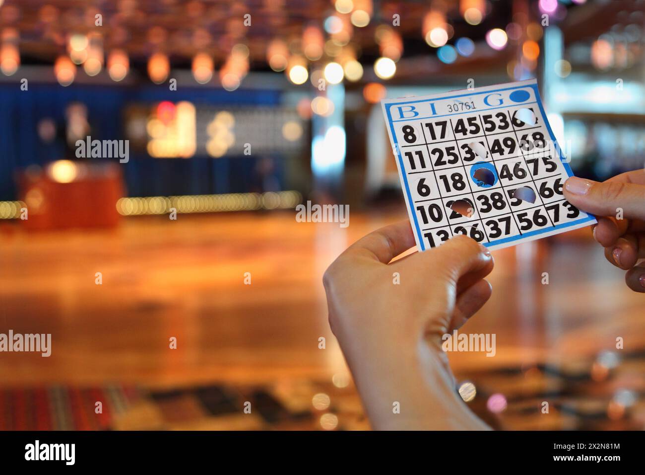Hands hold bingo card with holes at background of big board Bingo Stock ...