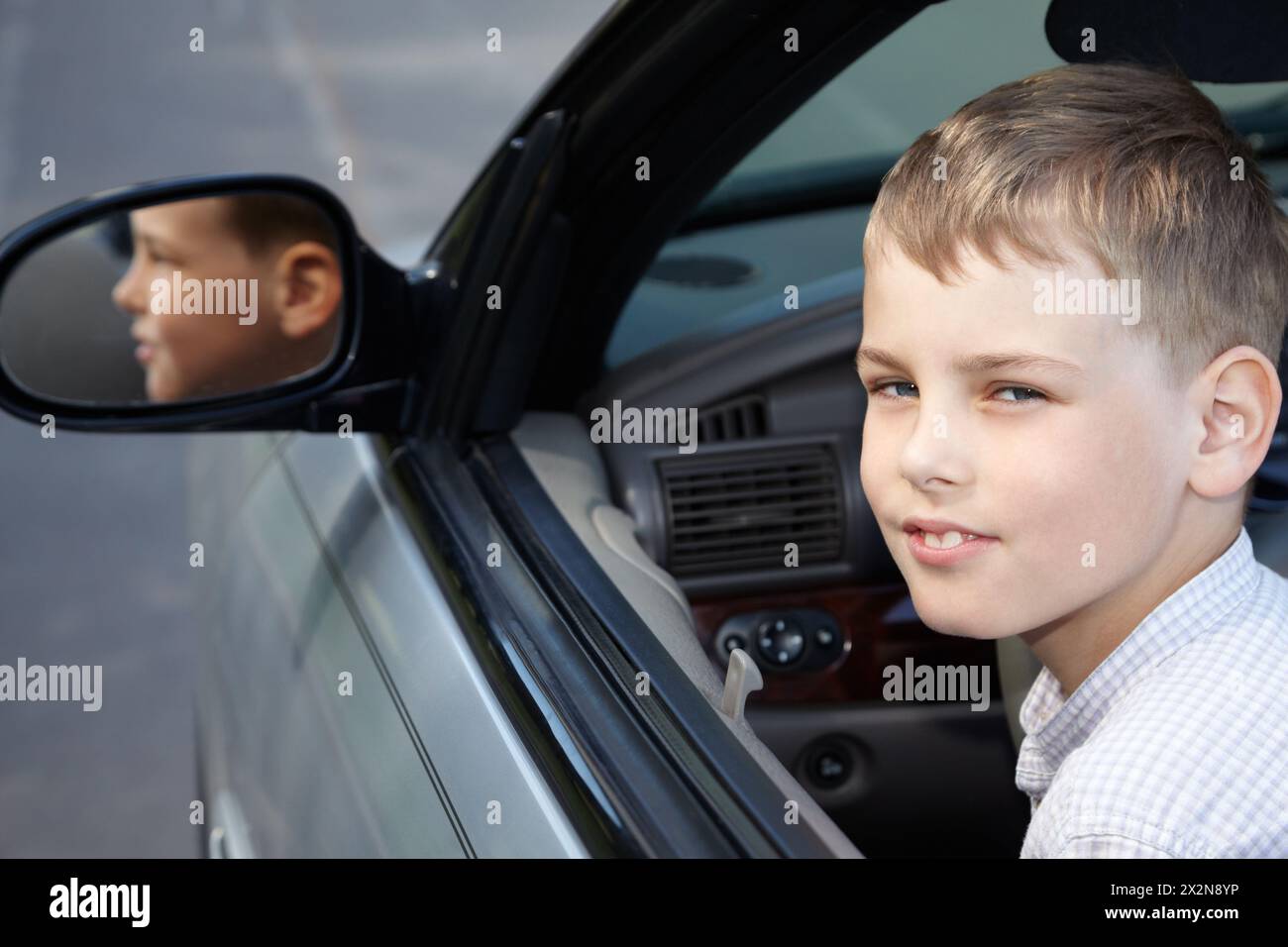 A boy sits half-turned back on a driver place in a open top car Stock Photo - Alamy