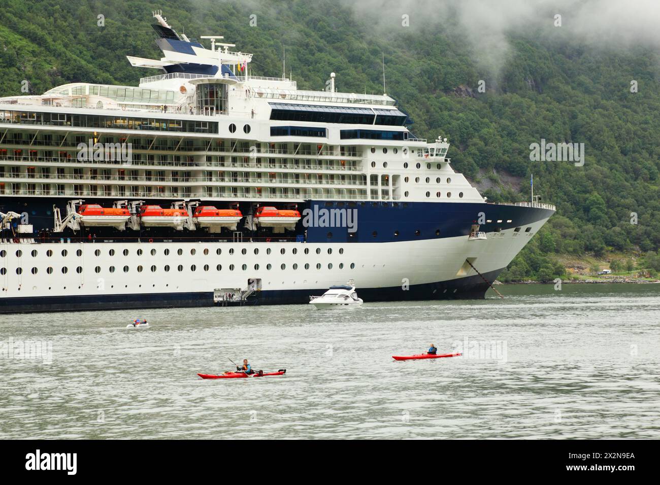 NORDDAL - JUNE 26: Two kayaks, yacht and rescue boat float on fiord ...