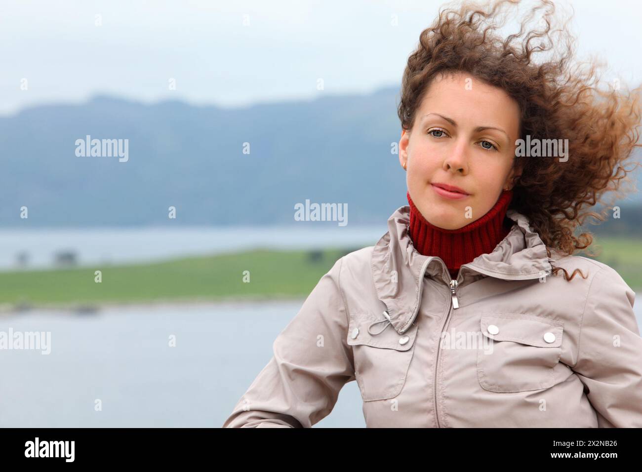 beautiful woman is on board ship and looks into distance; her hair ...