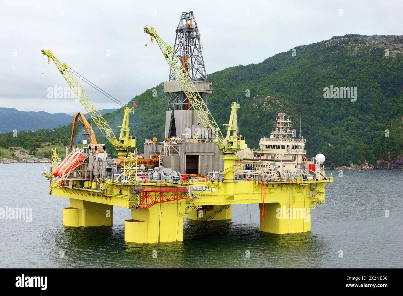 Ocean offshore oil rig drilling platform off near wooded shore of ...