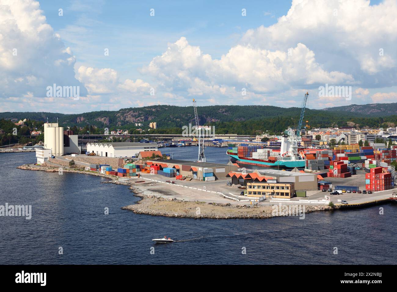 Small port. Containers are on shore. Cranes load cargo on ship Stock ...