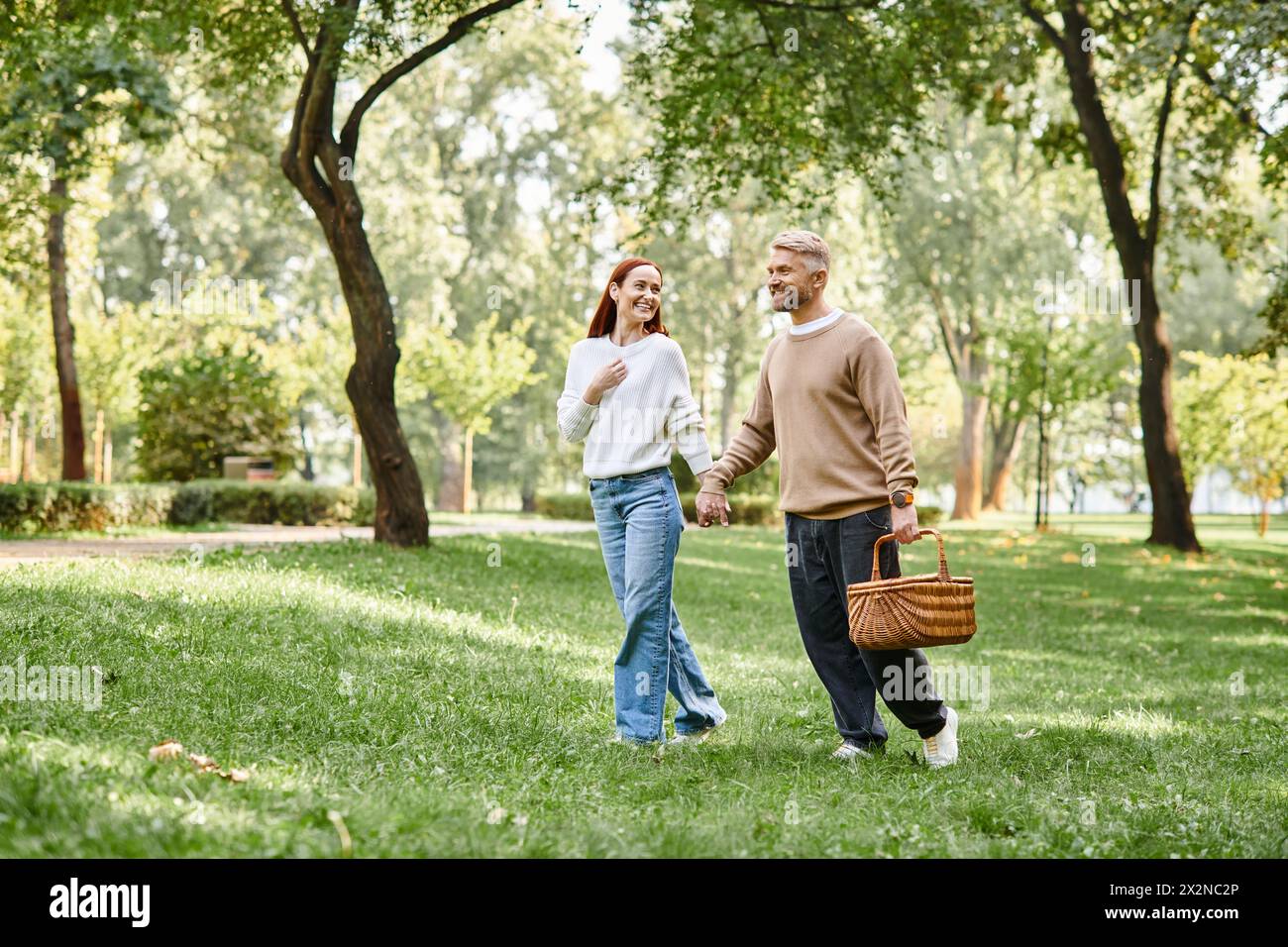 Couple walking through park holding hi-res stock photography and images ...