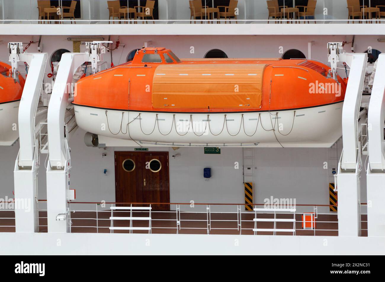 Orange lifeboat installed on large white passenger liner deck Stock ...