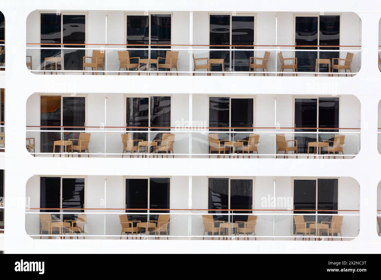 three rows of windows and balconies with chairs and tables on board of ...