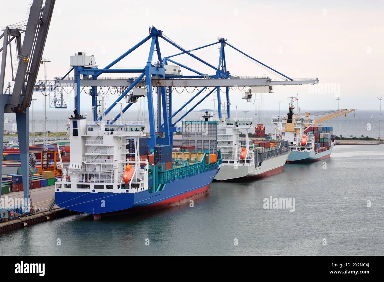 Three cargo shisp in Copenhagen seaport, Denmark; Cranes load cargo ...