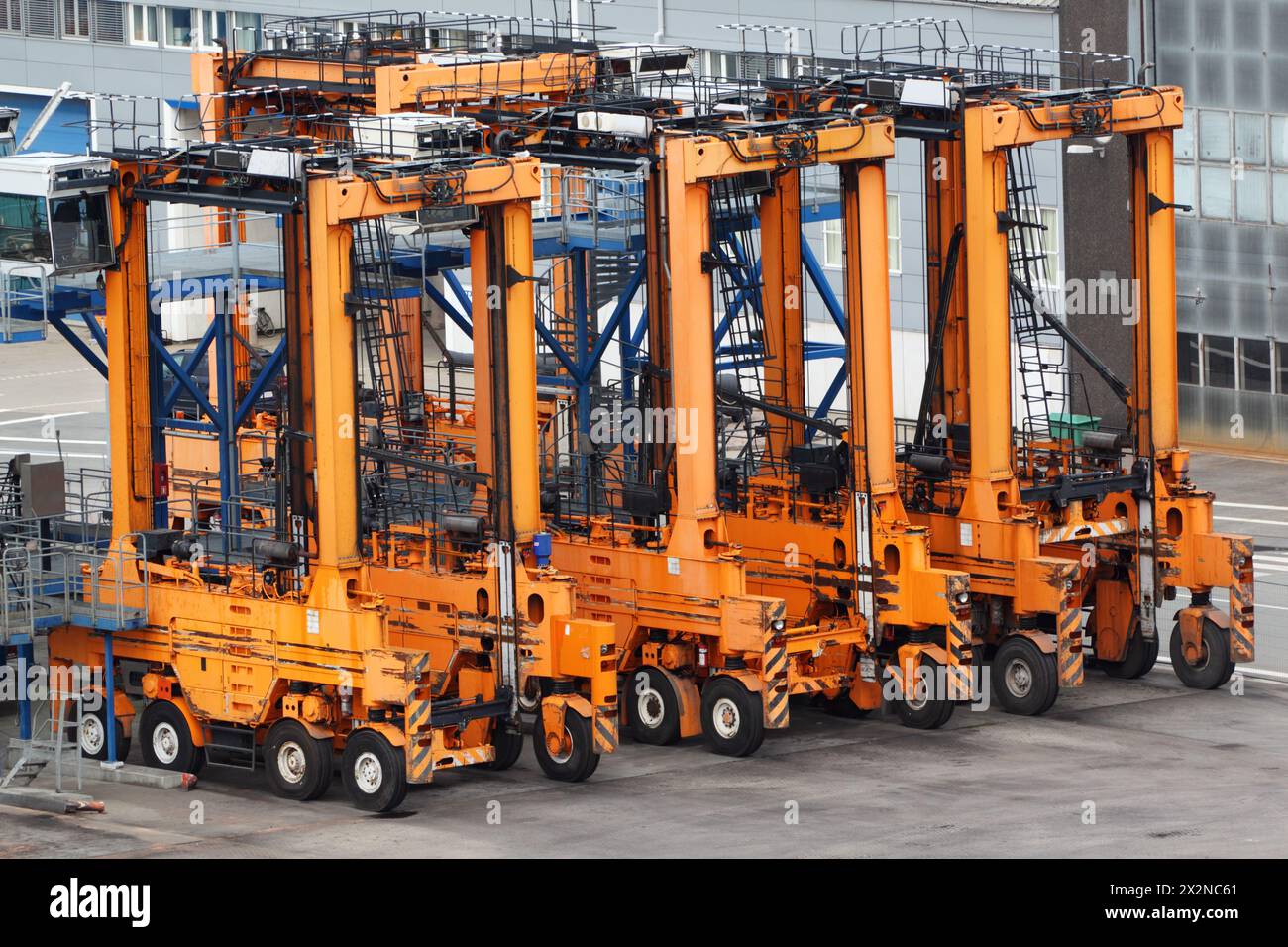 Many empty large orange loaders stand on asphalt in seaport Stock Photo ...