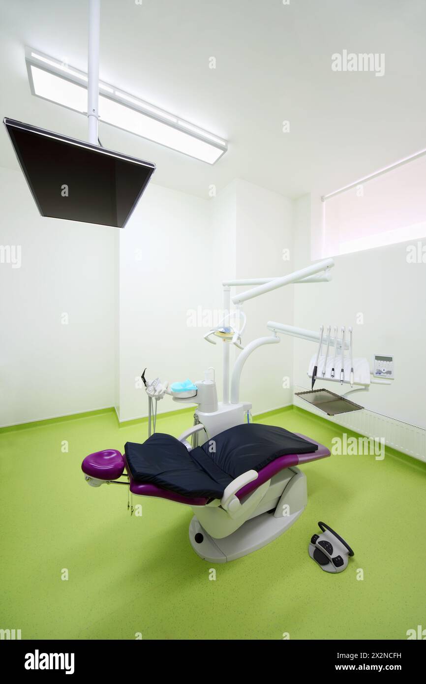Empty dental clinic. Chair and TV for patient and drill for dentist ...